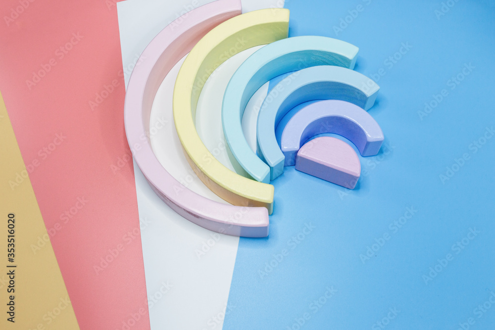 Wooden toy rainbow, pastel color arc on pink blue white orange ...