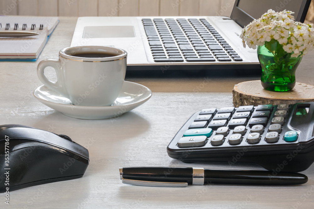 Cup of coffee, laptop with mouse, notebook with pen and calculator on ...