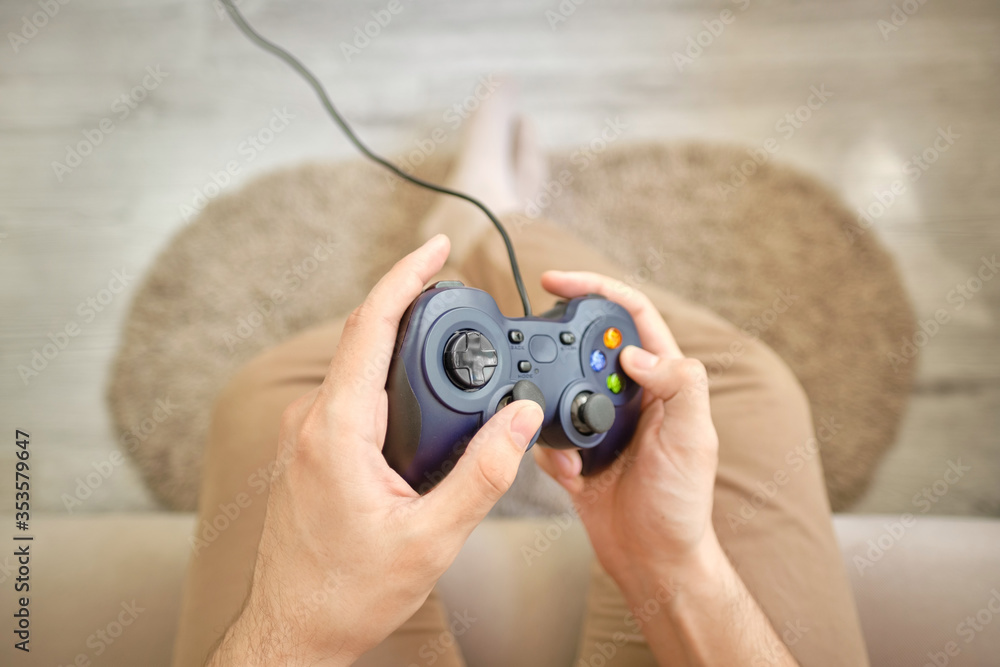 Excited young handsome man playing video game while sitting on the ...