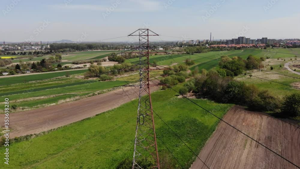 Power pylons and high voltage lines in an agricultural landscape. High ...