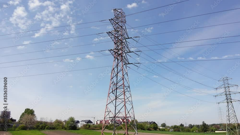 Power pylons and high voltage lines in an agricultural landscape. High ...
