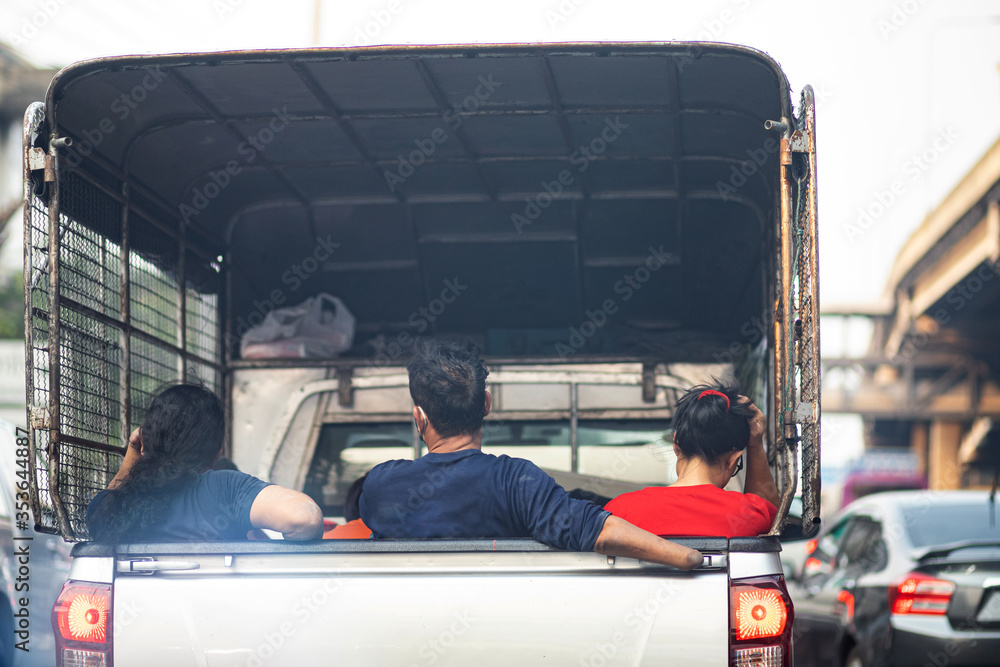 Rear view of workers sitting on pickup truck, People sitting on pick up ...