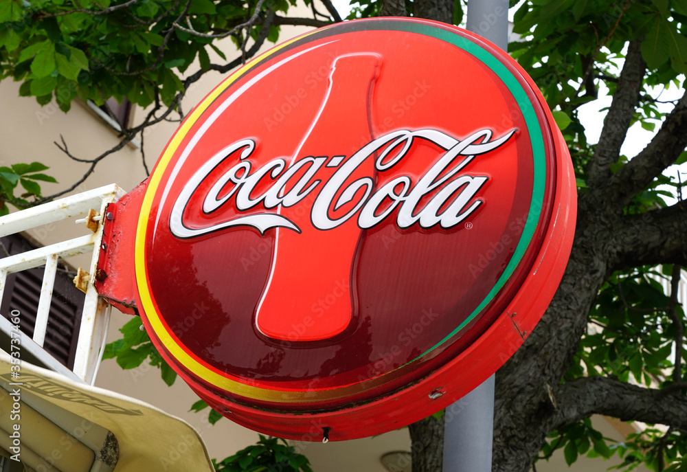 Coca-cola shield on a facade. Coca-Cola, or Coke, is a carbonated soft ...
