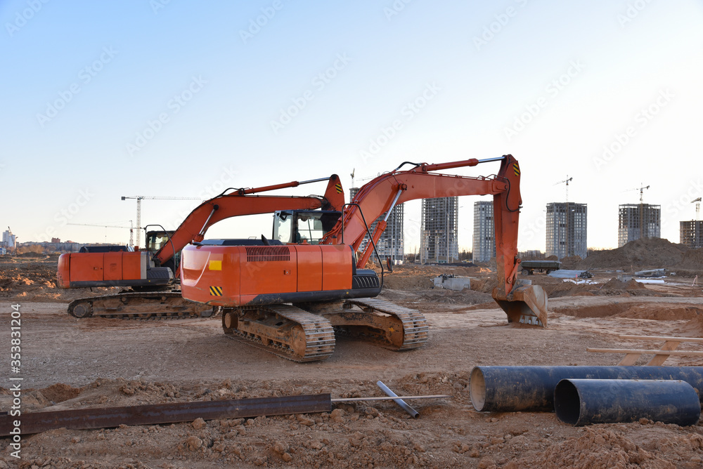 Excavators working at construction site. Backhoe digs ground for the ...