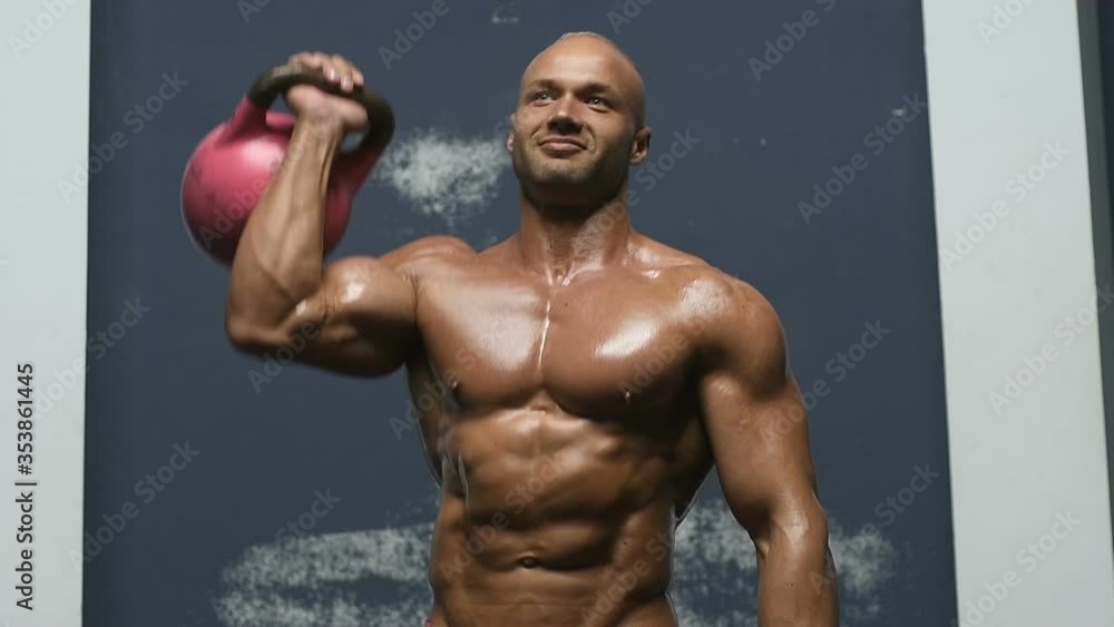 Bodybuilder handsome strong athletic rough man pumping up muscles with ...