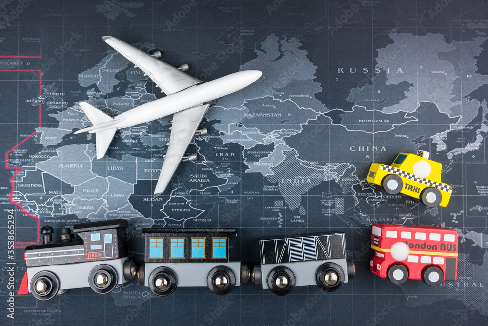 Wooden toy trains and toy airplanes on the world map. The ...