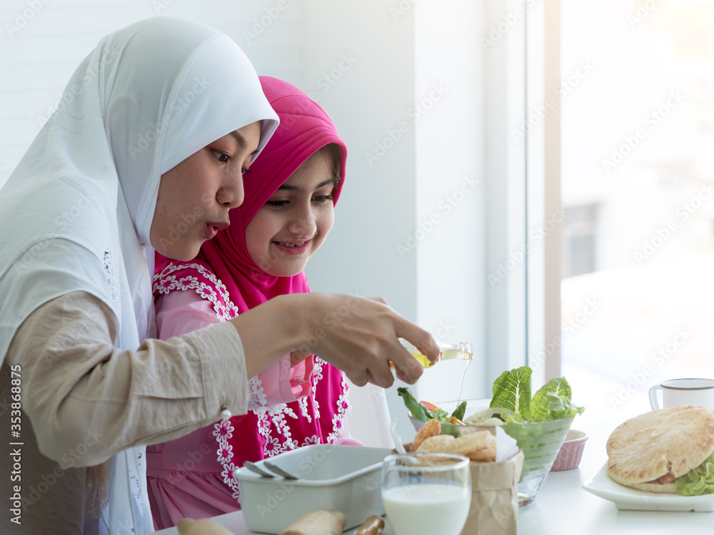 Muslim young lady with muslim girl helping to preparing lunch together ...
