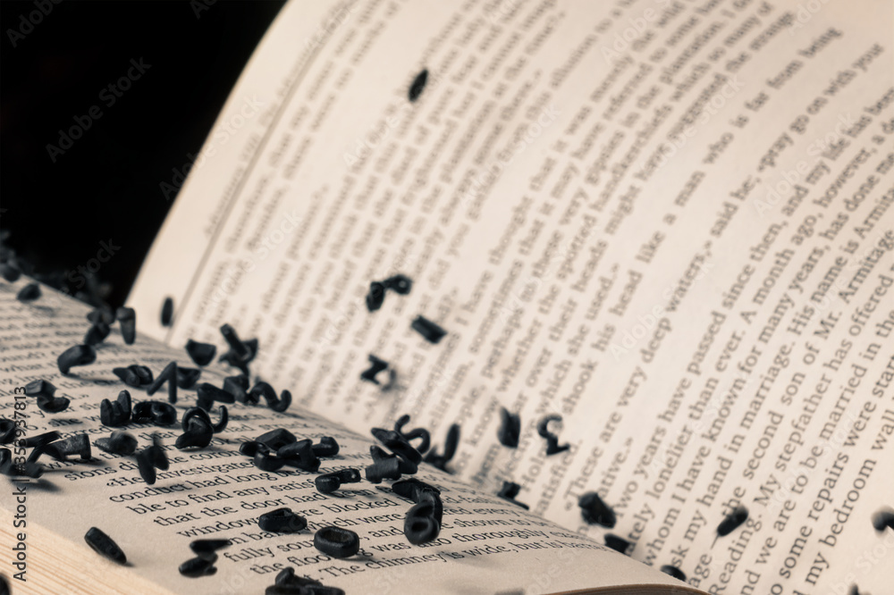 open book with falling black letters Stock Photo | Adobe Stock
