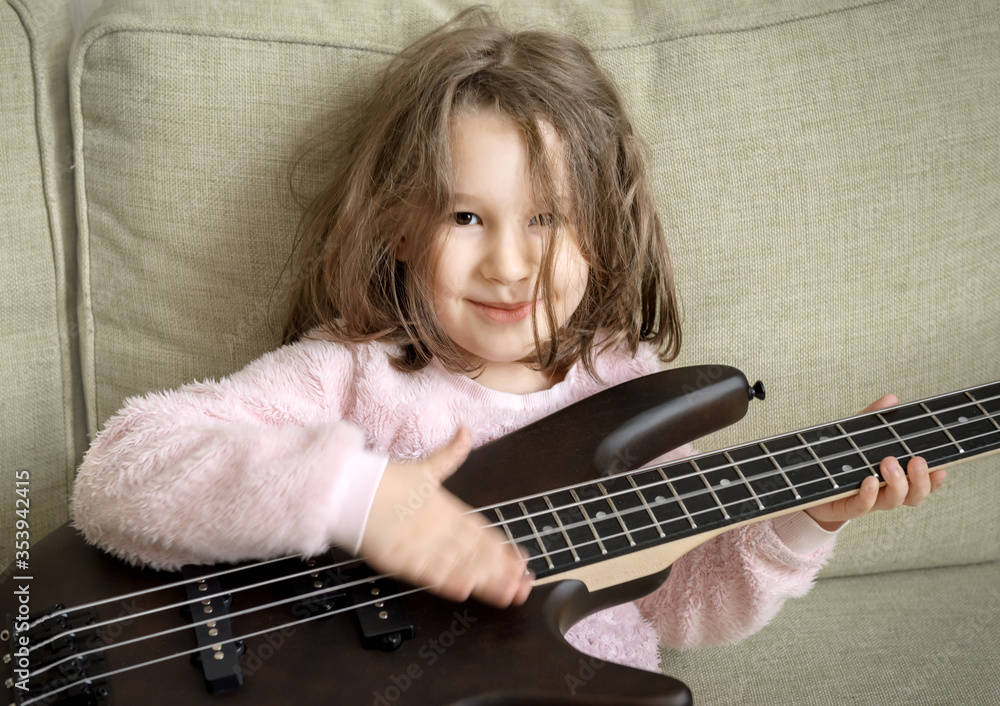 Kid playing bass guitar at home, portrait of little baby girl sitting ...