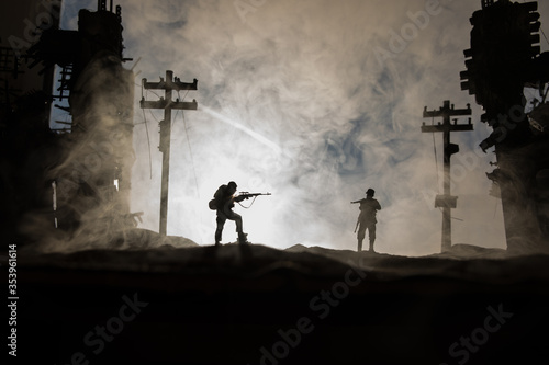 Army sniper with large caliber rifle standing in the fire and smoke ...