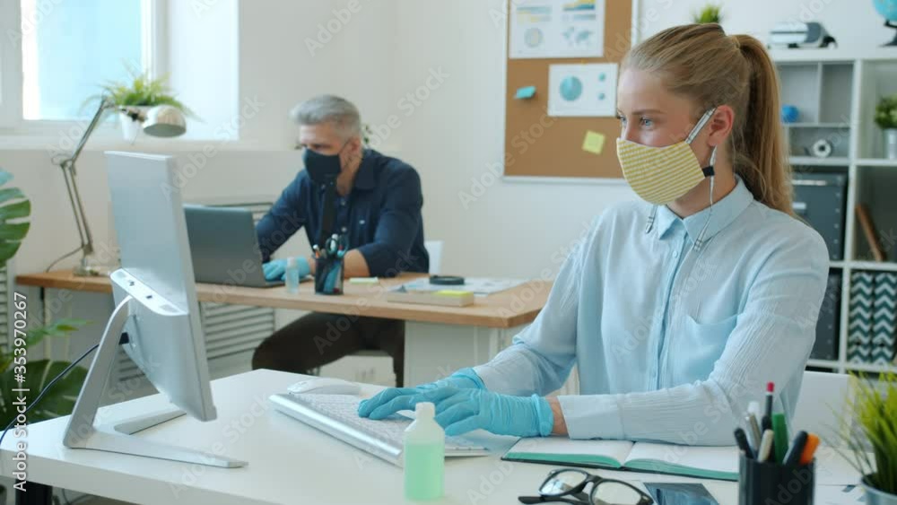 Business people in face masks and gloves are working with computers ...