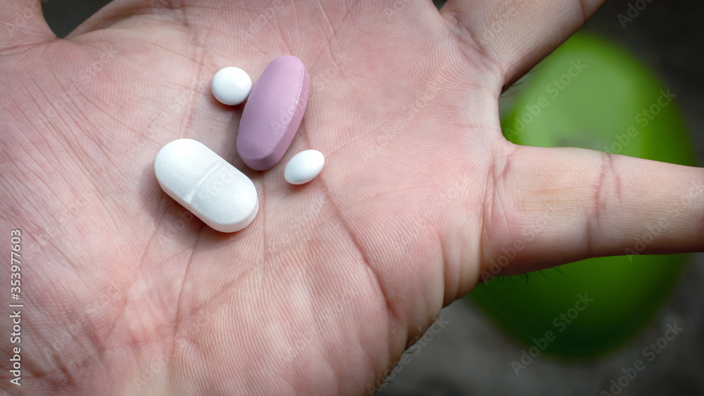 Pills in a palm hand look like human face: Painkiller pill, Antibiotics ...
