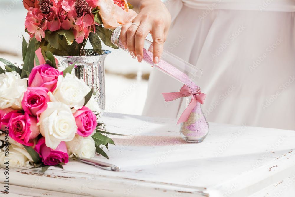 Bride and groom pouring colorful different colored sands into the ...