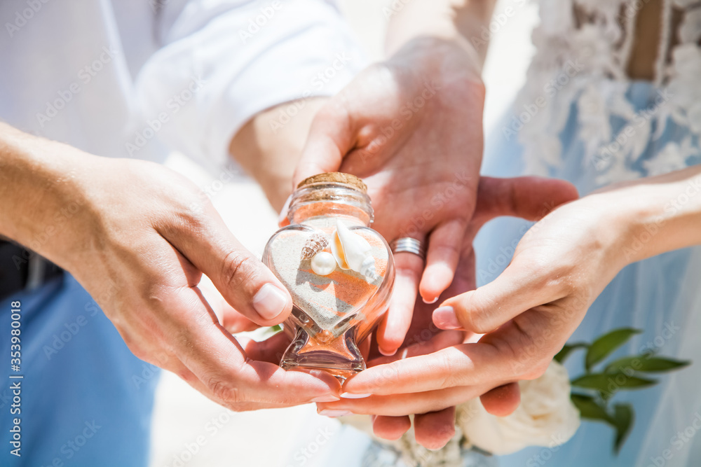 Bride and groom pouring colorful different colored sands into the ...