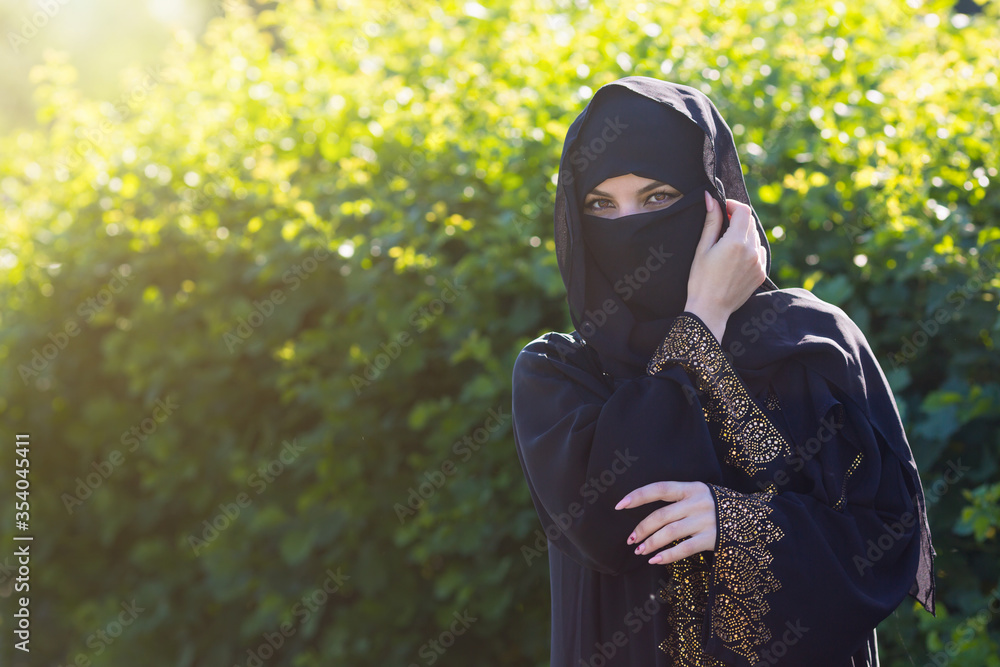 Beautiful muslim woman on a background of green leaves. Islamic woman ...