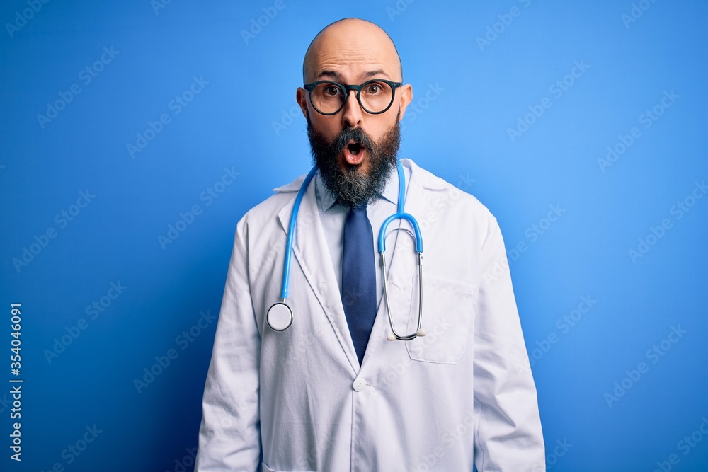 Handsome bald doctor man with beard wearing glasses and stethoscope ...