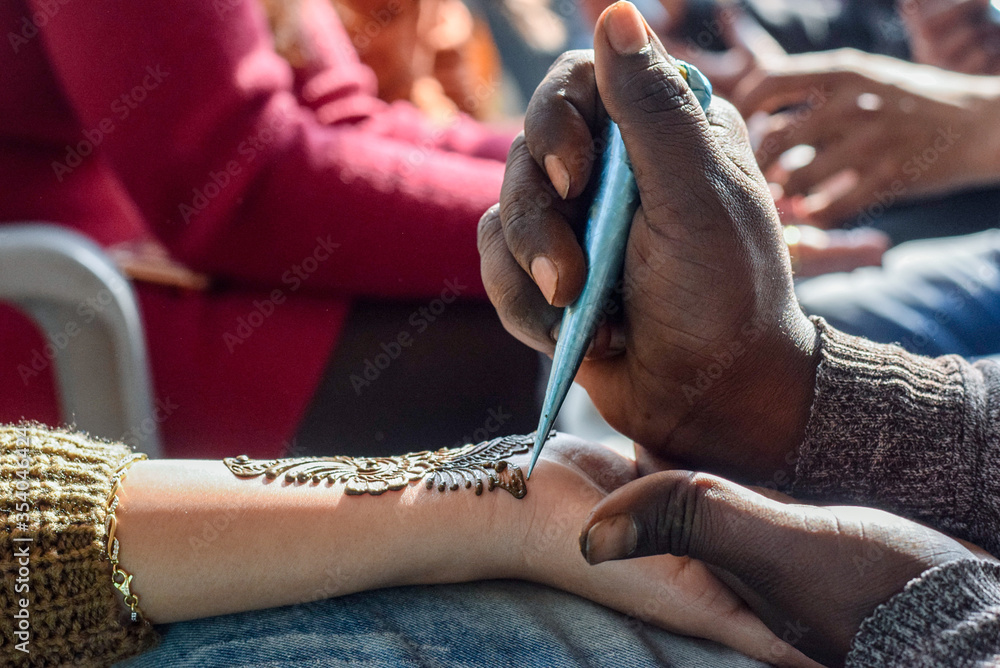 Girl getting Henna/Mehendi applied on her hand during a celebration in ...