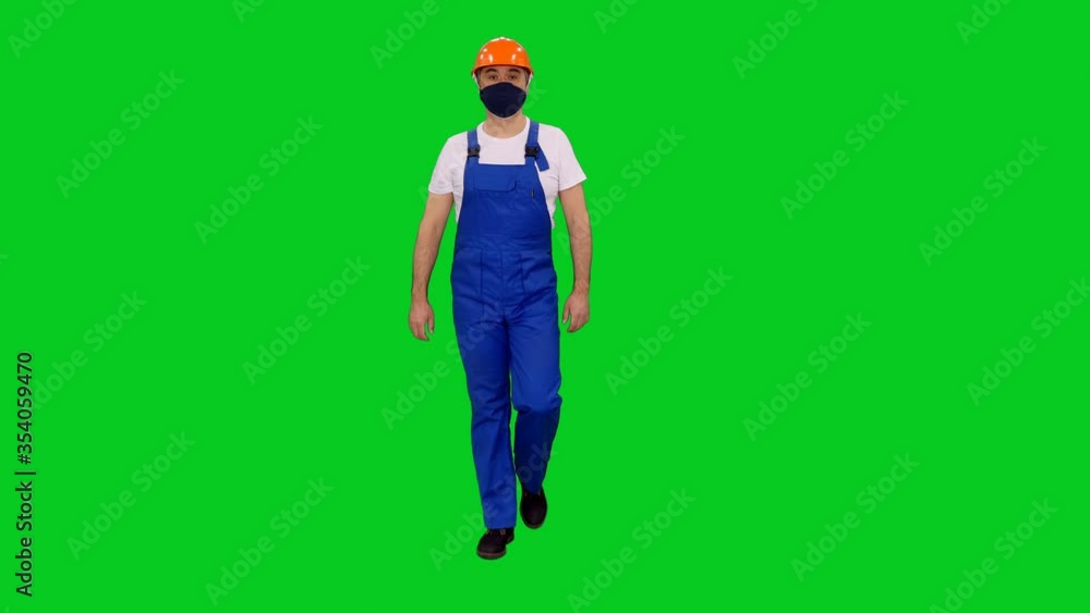 Foreman in protective mask and blue uniform with red hard hat walking ...