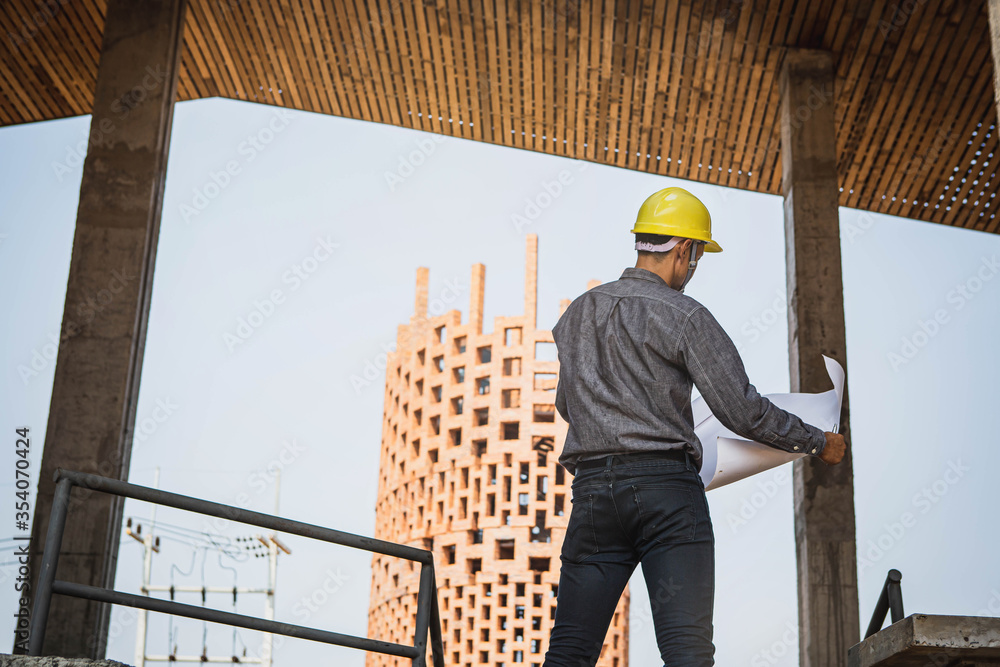 Architucture in hardhat and blueprint posing on building site. civil ...