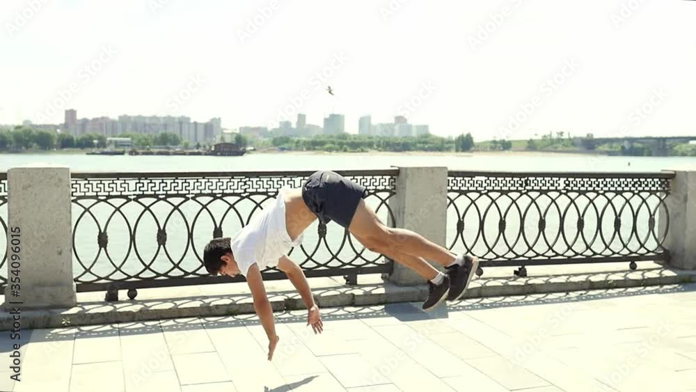 A young gymnast runs around the city and does a series of somersaults ...