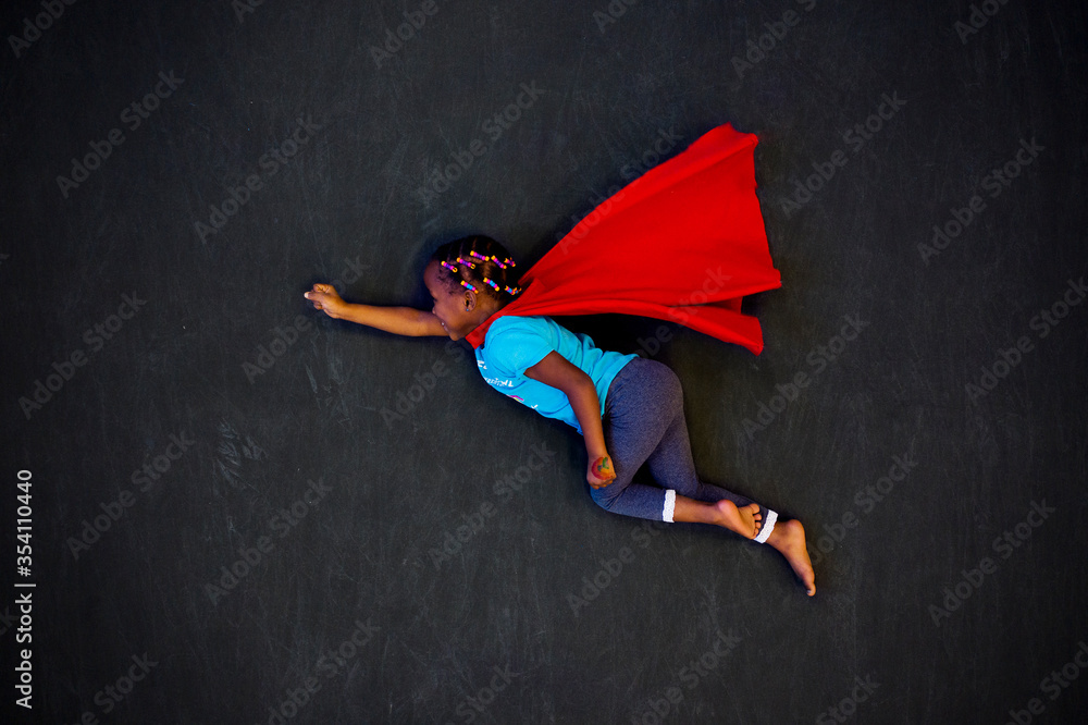 Super hero kid flying though the night sky. Stock Photo | Adobe Stock
