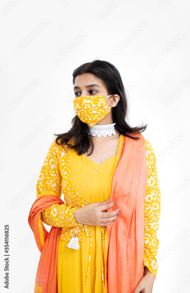 Indian girl wearing a mask with traditional Indian outfit. Stock Photo | Adobe Stock