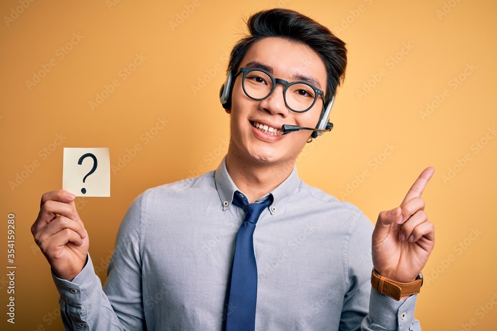 Young handsome chinese call center agent man holding paper with ...