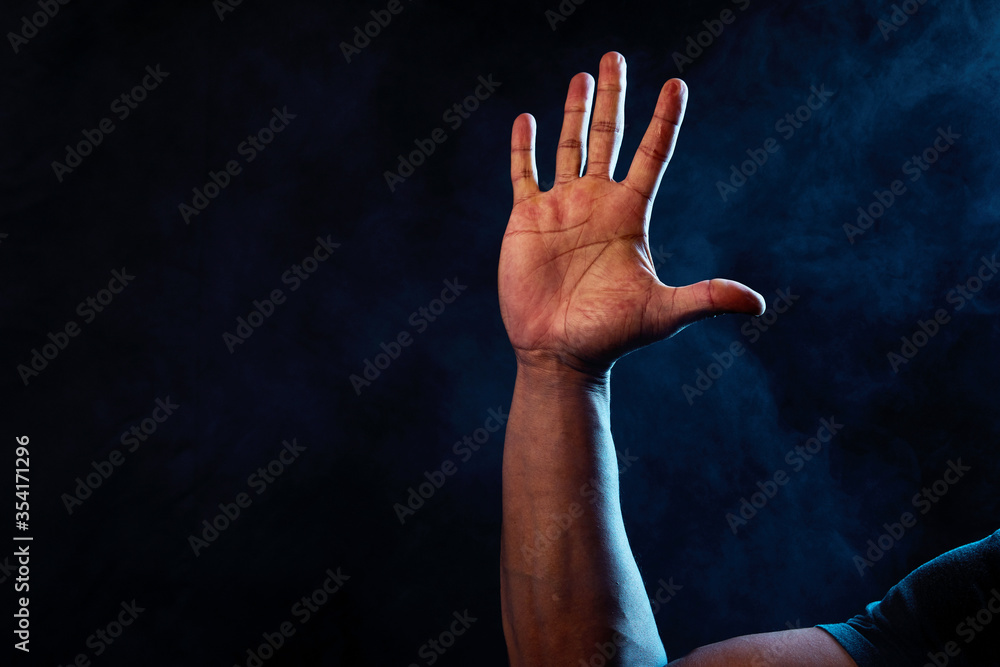 Studio image of an African American hand held up in surrender with ...