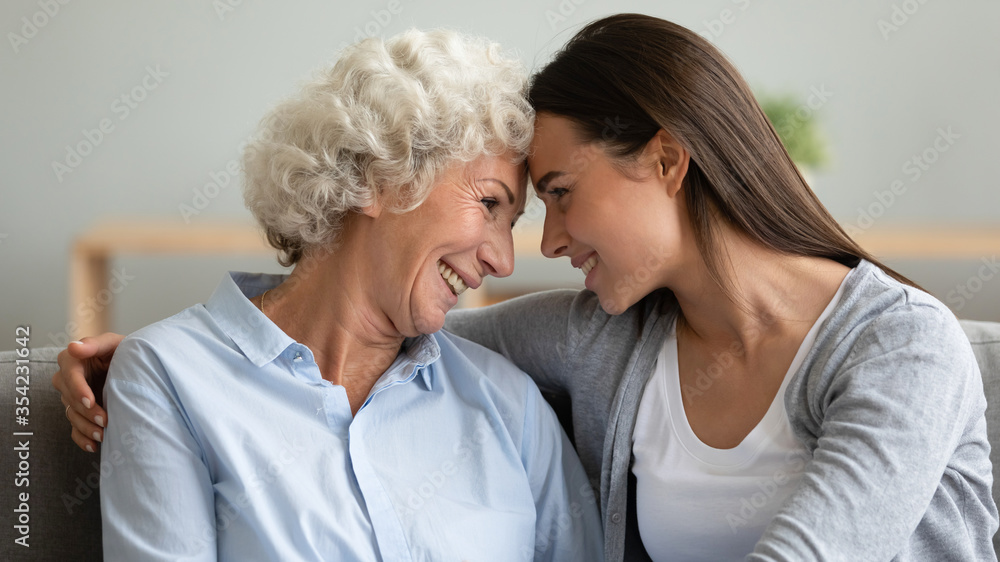 Close up profile faces multi-generational women sit on sofa adult ...