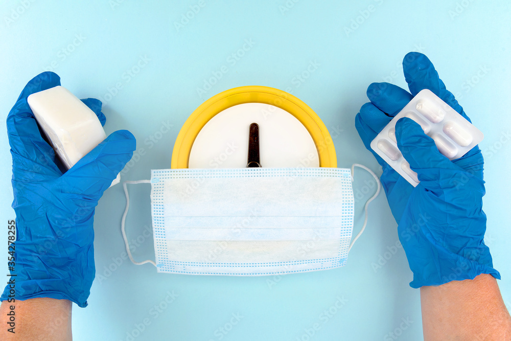 Person wearing blue nitrile surgical gloves holding soap and ...