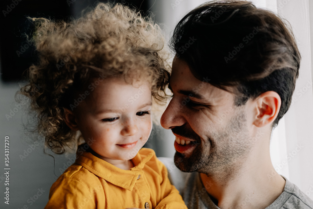 father and daughter. Young pretty dad and his little curly daughter ...