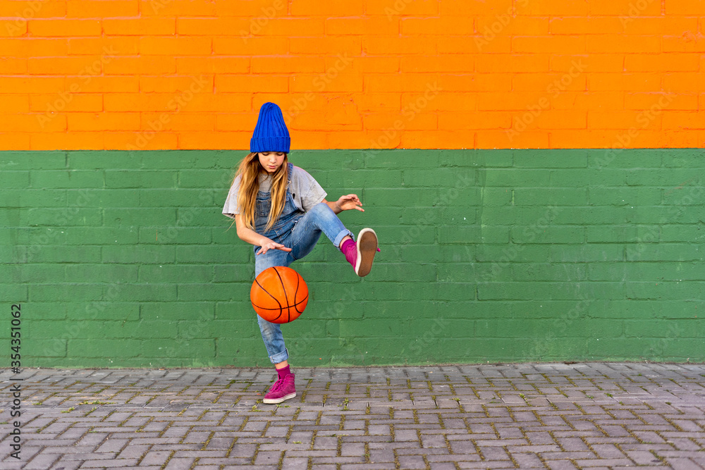 Young girl playing basketball, dribbling and lifting leg Stock Photo ...
