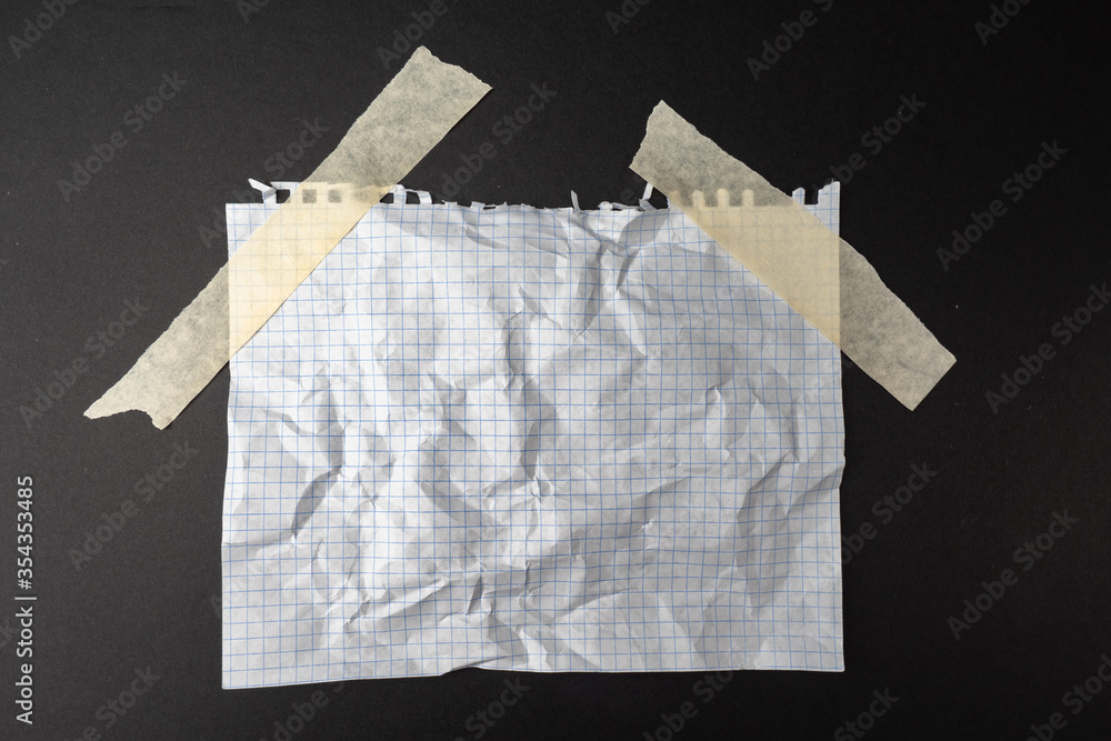 A piece of paper is taped to the black wall. Sticky tape in the design ...