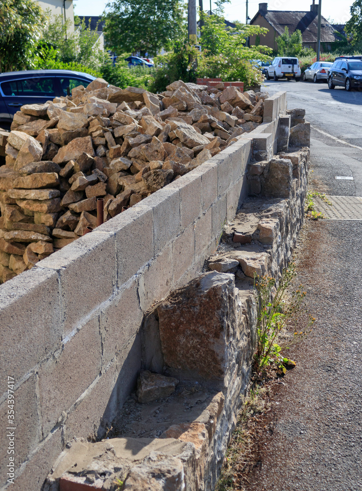 Natural stone wall construction. Built next to a breeze block wall for ...