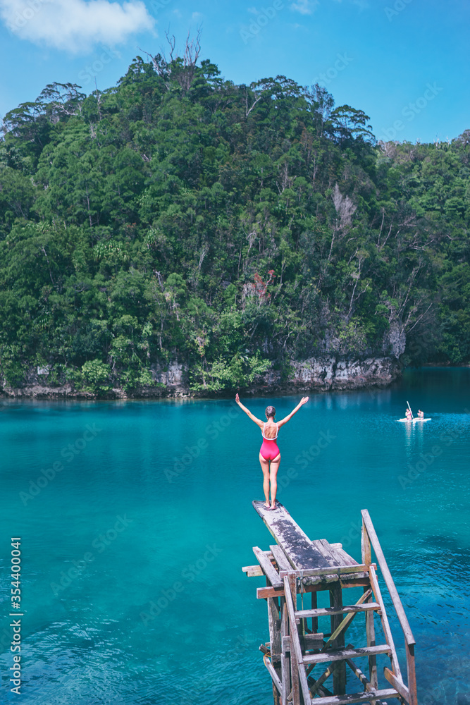 Vacation and activity. Young woman in swimsuit enjoying blue tropical ...