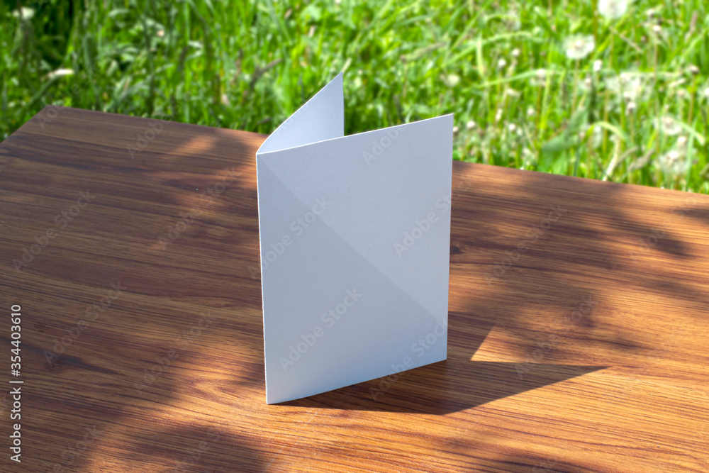 Blank bifold table card, empty flyer standing on a wooden table ...