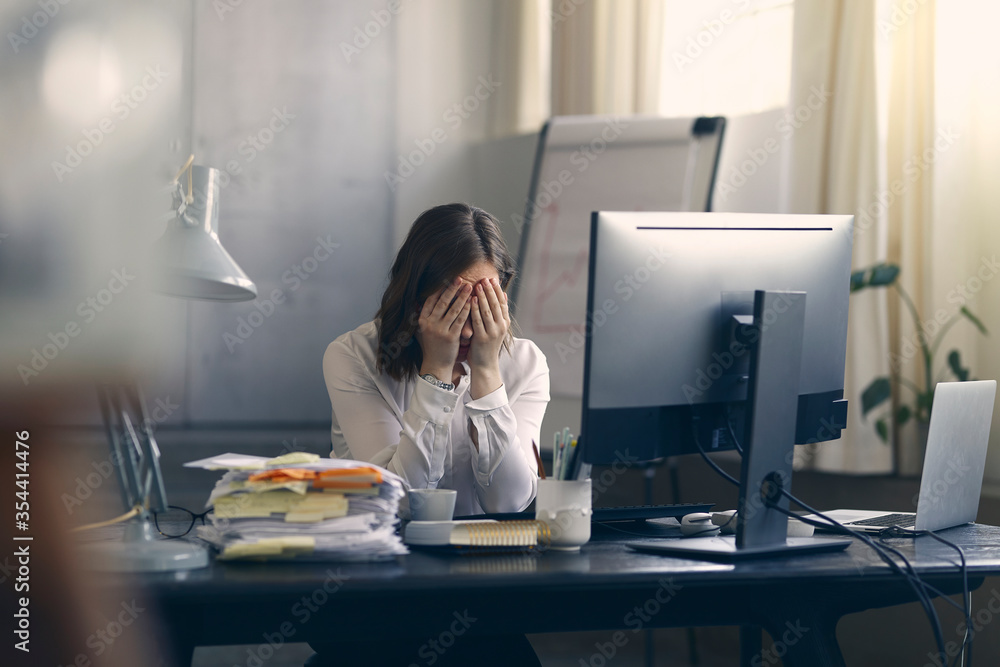 Very stressed business woman sitting in front of her computer with her ...