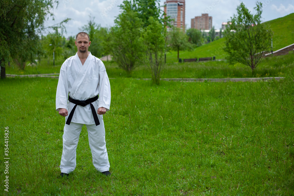 Training in the fresh air. A karate trainer stands and holds his hands ...