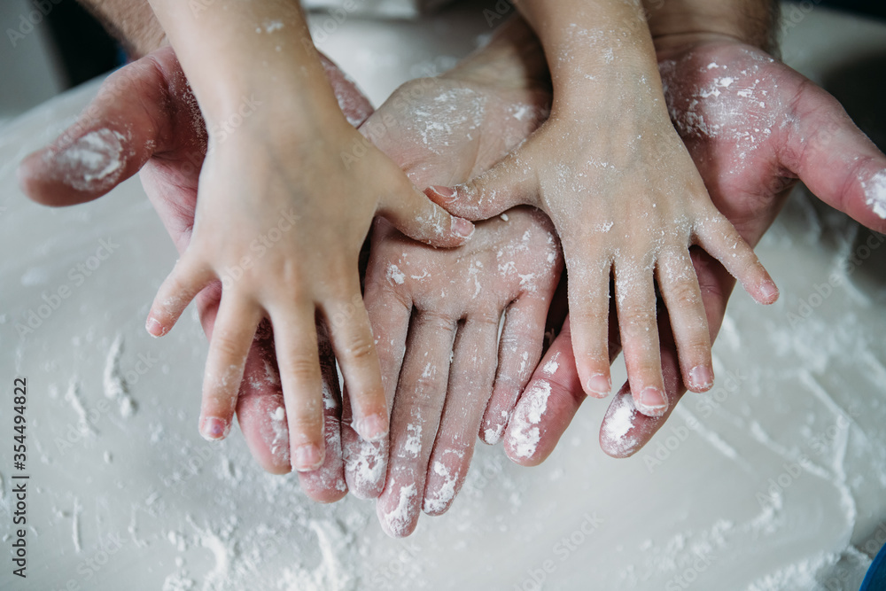 Family hands in flour.The hands of a family that cooks something out of ...