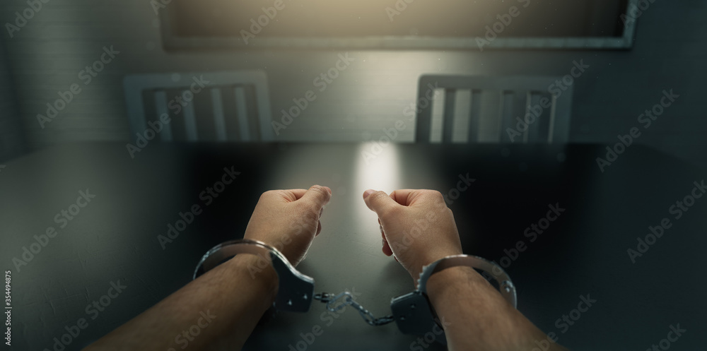 handcuffed hands in an interrogation room / composite on a 3D ...