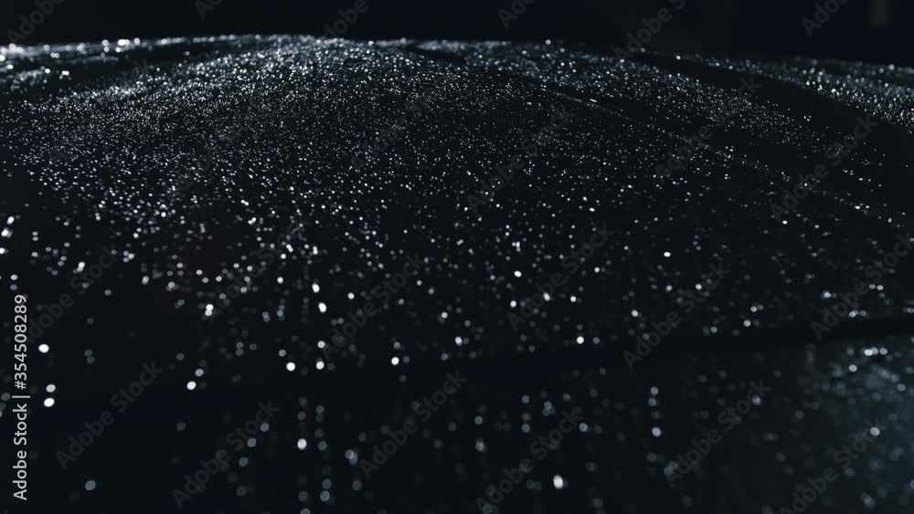 Drop flow down the hood. Close up view of a bonnet car. Dark black ...