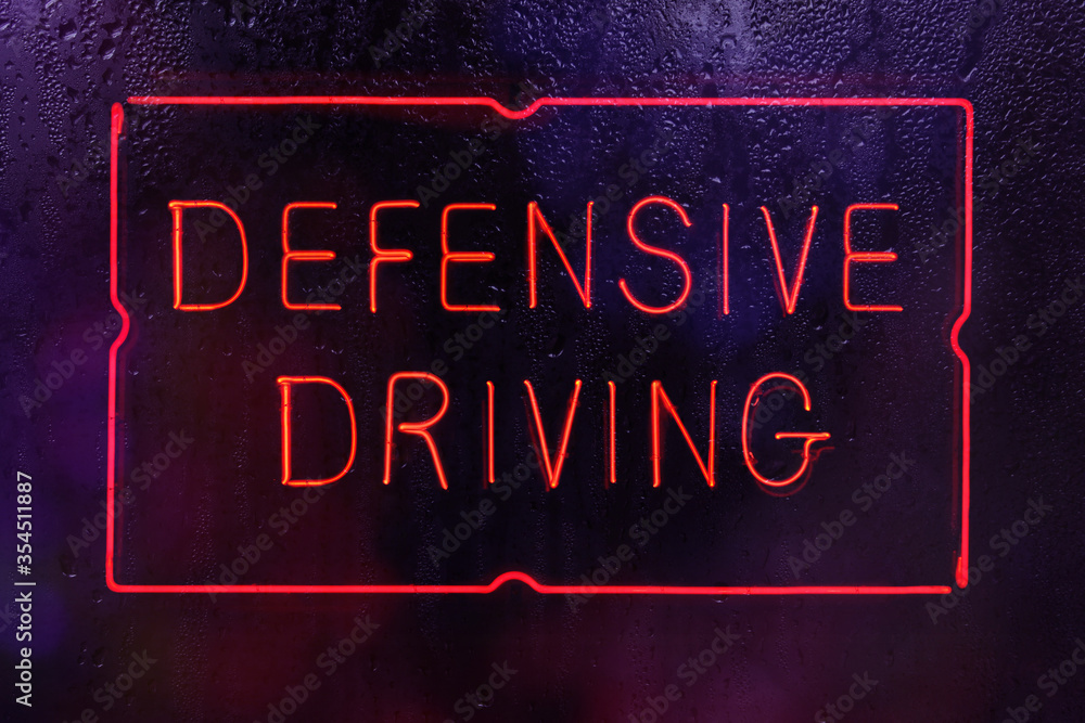 Vintage Neon Defensive Driving Sign in Rainy Window Stock Photo | Adobe ...