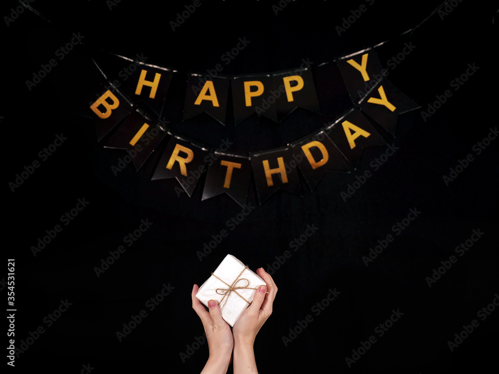 Faceless person holding a white gift in his hands on a black isolated ...