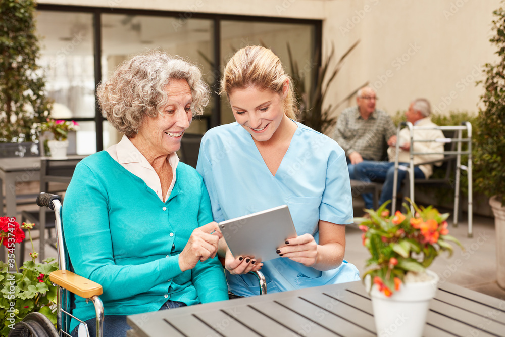 Senior citizen and caregiver using a tablet PC Stock Photo | Adobe Stock