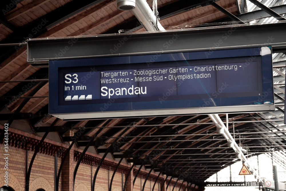 A train station sign showing the next train and its destinations on a ...