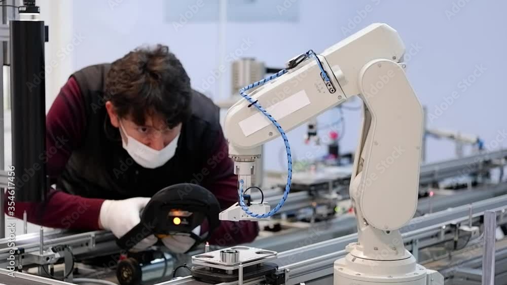 Close-up robot arm. Man with surgical mask on face against COVID-19 ( Coronavirusis ...