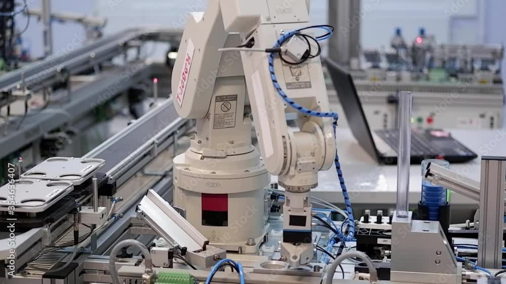Close-up of robot arm pick product from automated car and place to ...