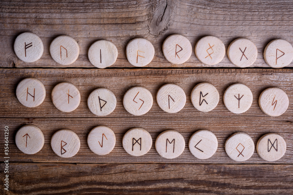 Wooden runes on a wood background. Ancient alphabet known as the ...