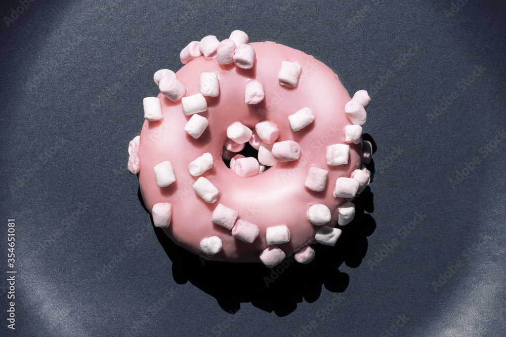 Top view of delicious single pink donat with white marshmallows on the ...