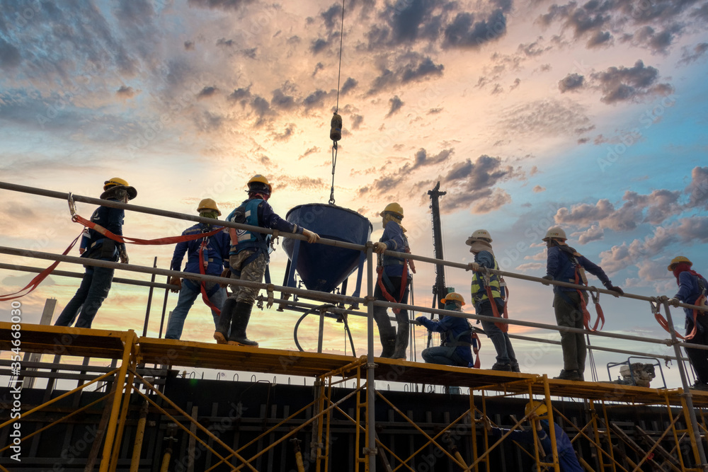 A construction worker wearing PPE pouring a concrete at construction ...